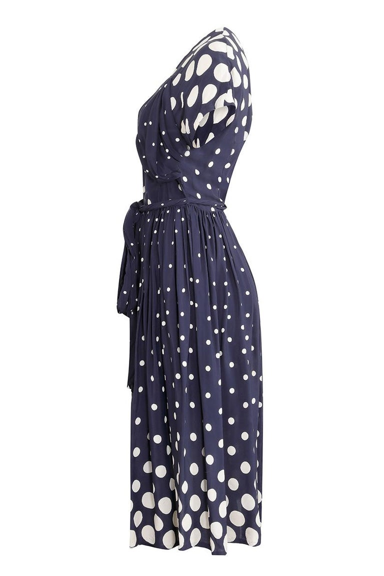 1940er Jahre Marineblaues und weißes Polkadot-Kleid mit Schleifendetail ...