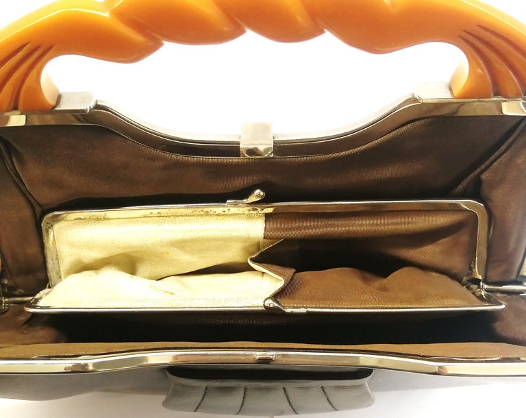 A brown leather handbag, with a carved amber Bakelite handle, English ...