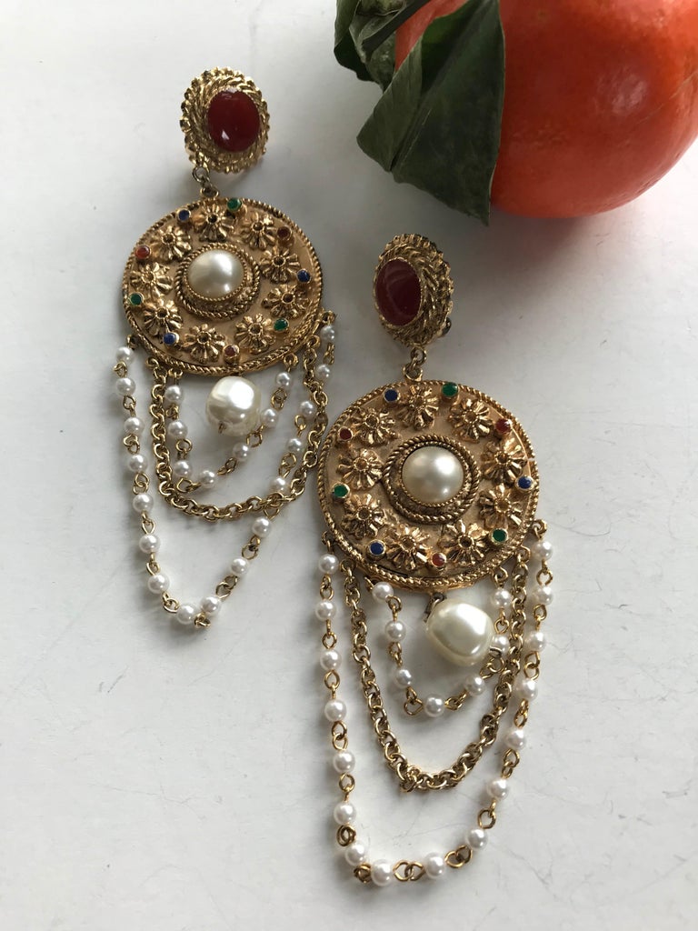A decorative unsigned ear clip gold-plated with false pearls and chains ...
