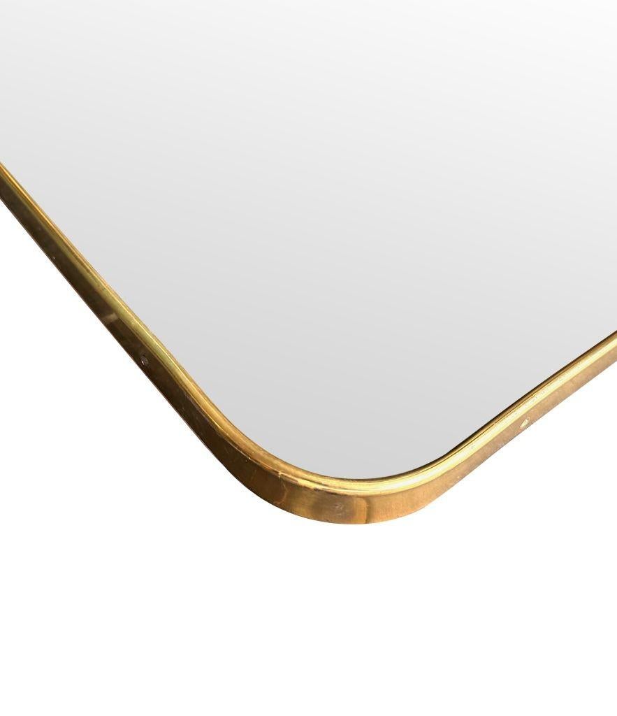 A large orignal 1950s Italian brass framed mirror with wide proportions ...