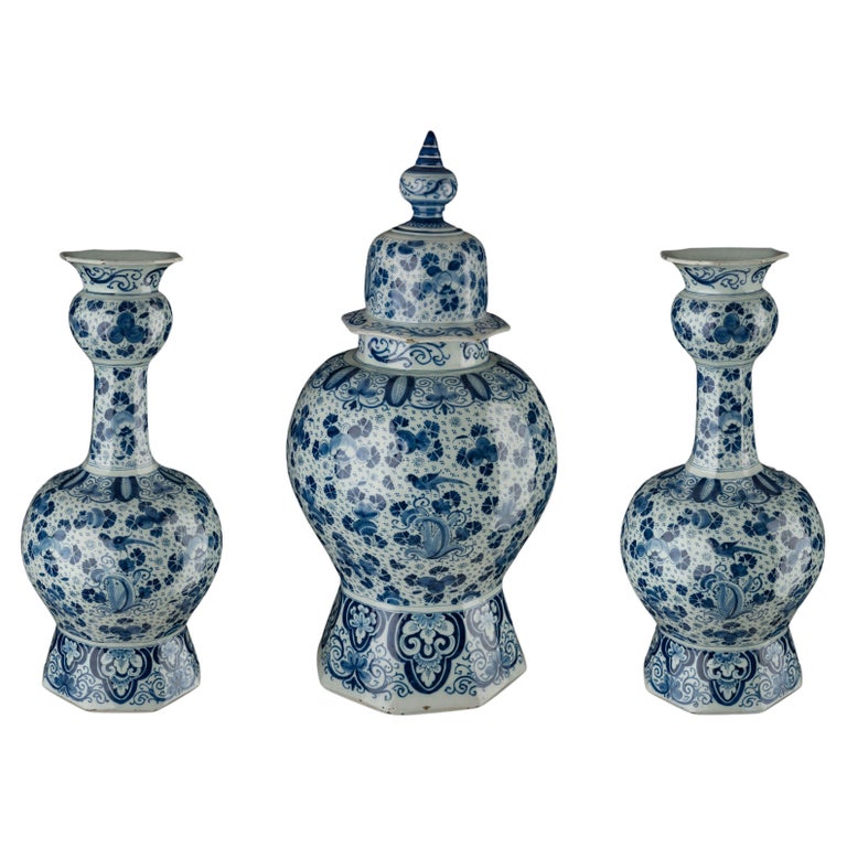 A very large three piece garniture with floral decor. Marked. Delft ...