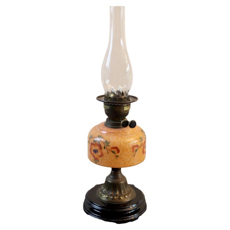 A Victorian oil lamp with orange, opaque and floral patterned reservoir ...