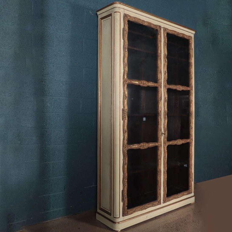 An imposing pair of cream painted and parcel gilt large bookcases ...