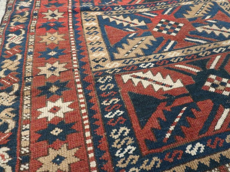 Distressed Caucasian Rug With A Tribal Design In Rust, Dark Blue, And ...