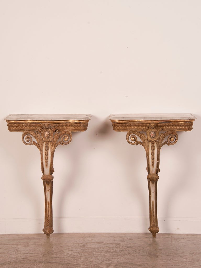 A pair of gilded and painted single leg console tables from Italy c ...