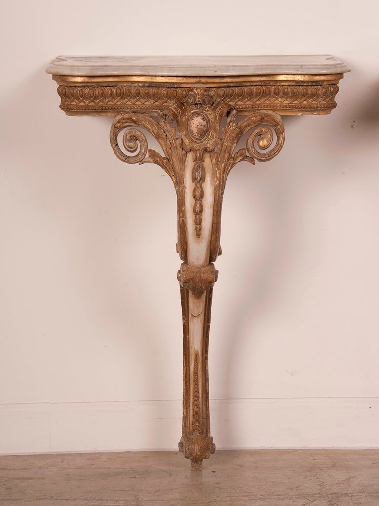 A pair of gilded and painted single leg console tables from Italy c ...