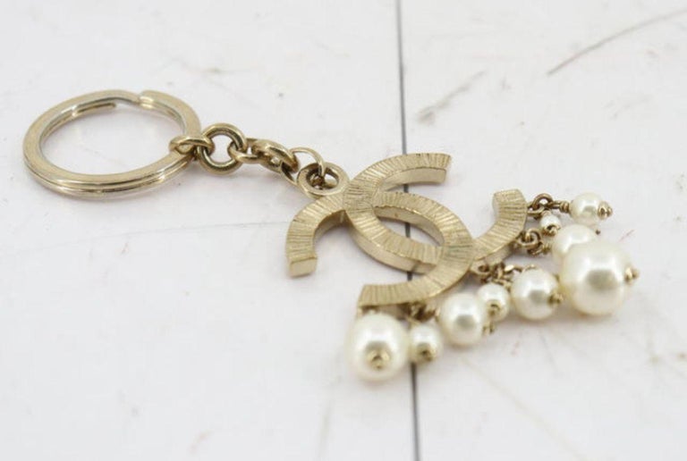 Chanel CC key chain is crafted in light gold-tone hardware and features ...