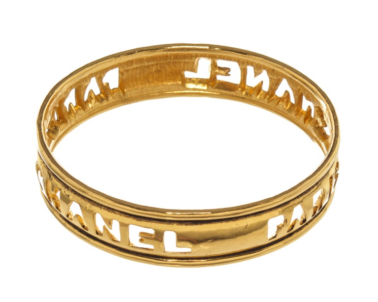 Chanel Gold Metal Cut Out Logo Bangle Bracelet For Sale at 1stDibs