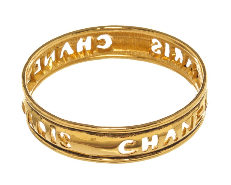 Chanel Gold Metal Cut Out Logo Bangle Bracelet For Sale at 1stDibs