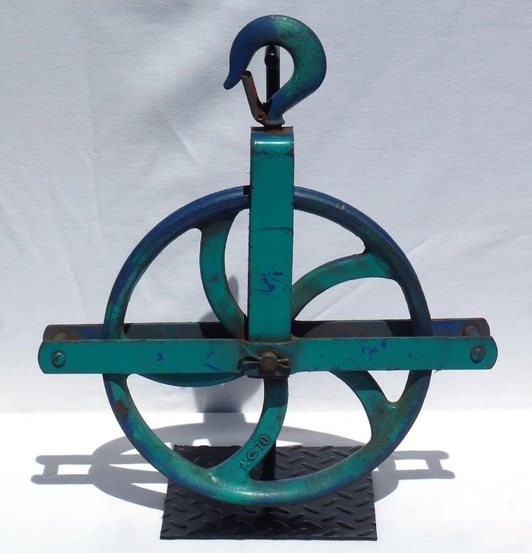 Colorful dark blue and teal large industrial cast iron pulley on a ...