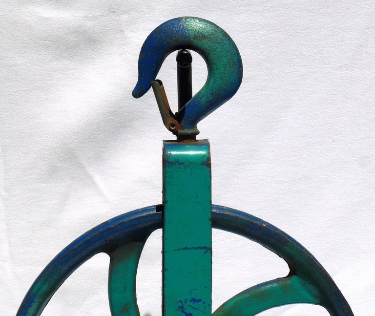 Colorful dark blue and teal large industrial cast iron pulley on a ...