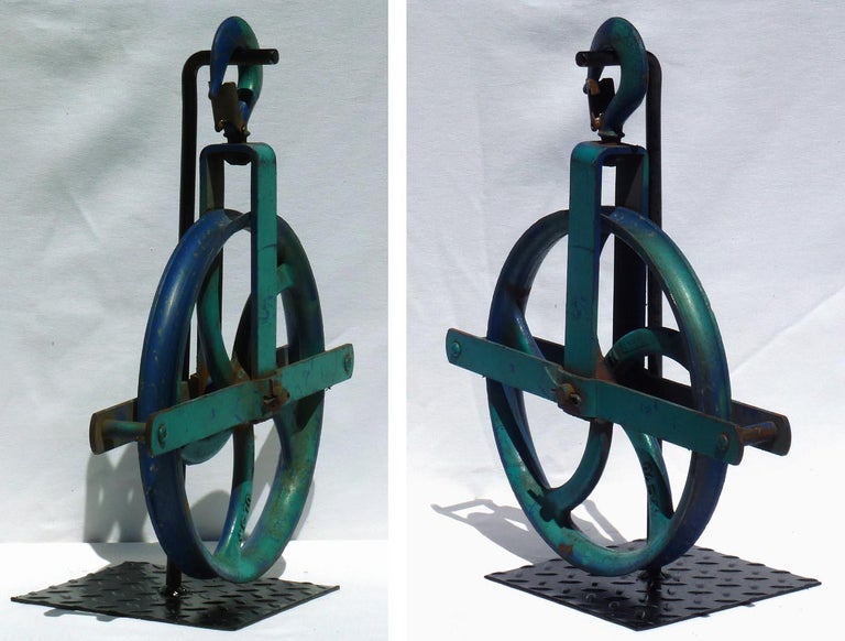 Colorful dark blue and teal large industrial cast iron pulley on a ...