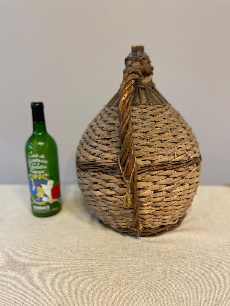 French Glass Demijohn Bottle in Woven Basket at 1stDibs