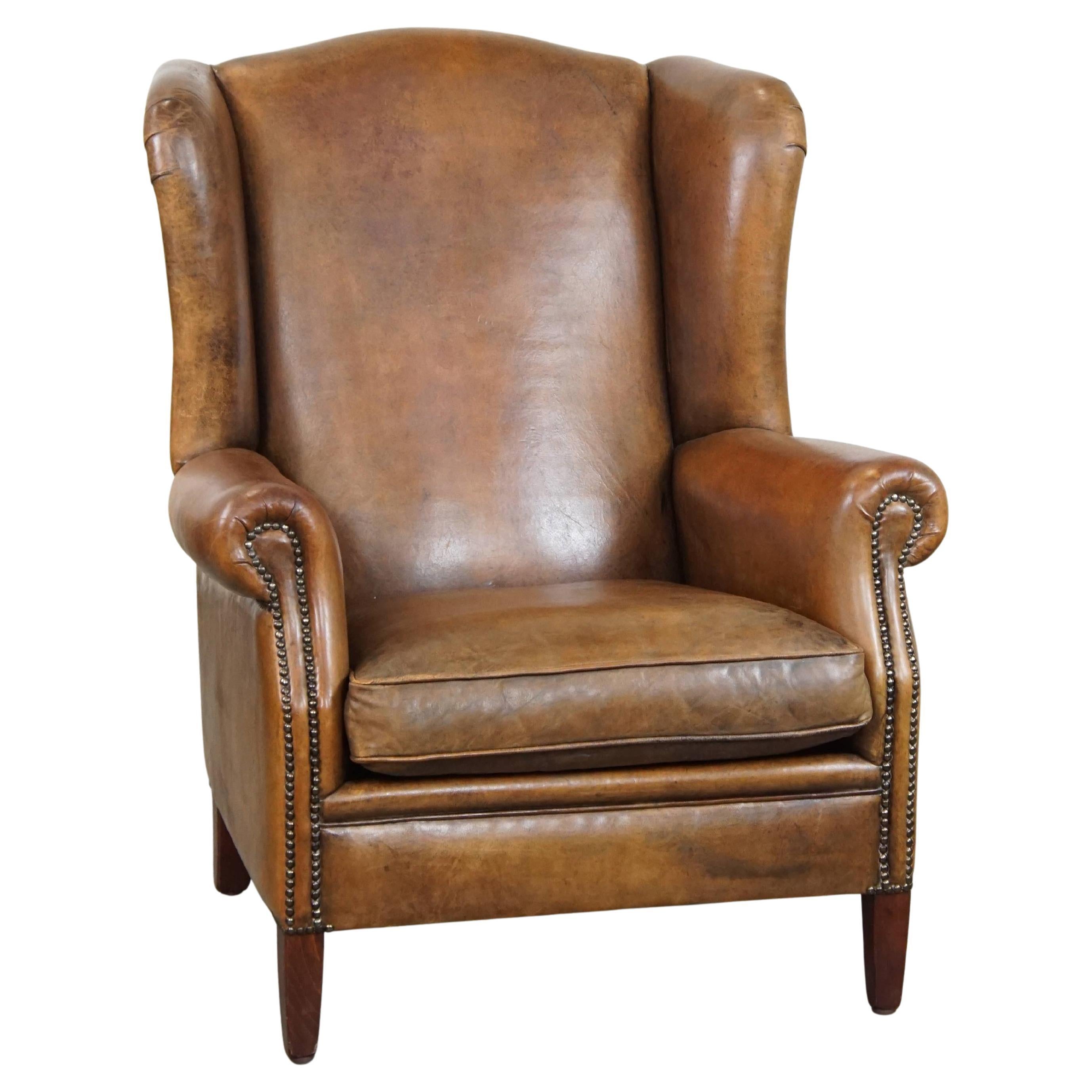 Large cognac-colored leather wingback chair in good condition in ...