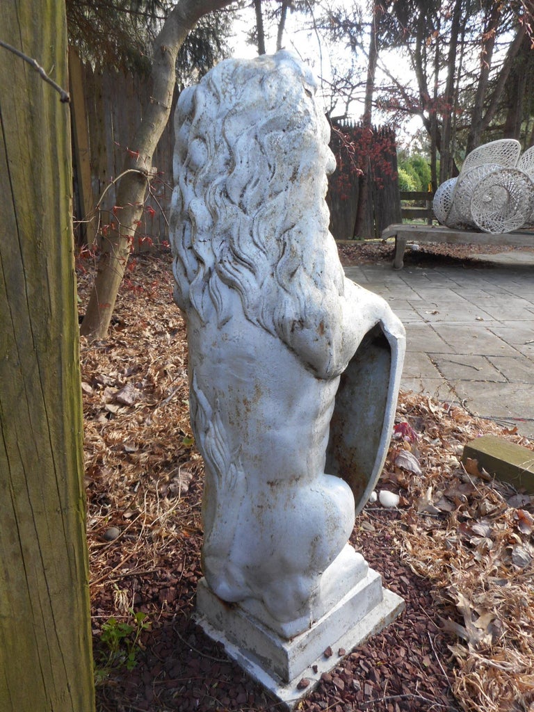 Pair of Cast Iron Lion Statues Holding a Shield For Sale at 1stDibs
