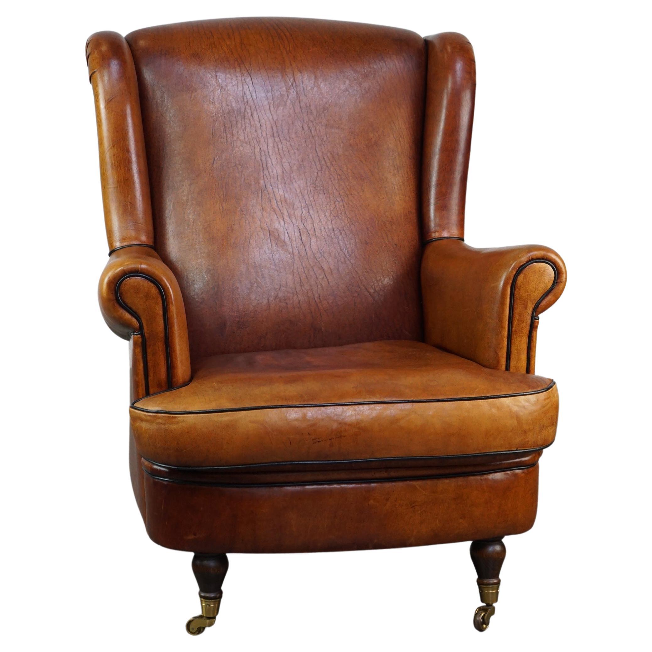 Subtle sheepskin wing chair in good condition on brass front wheels For ...